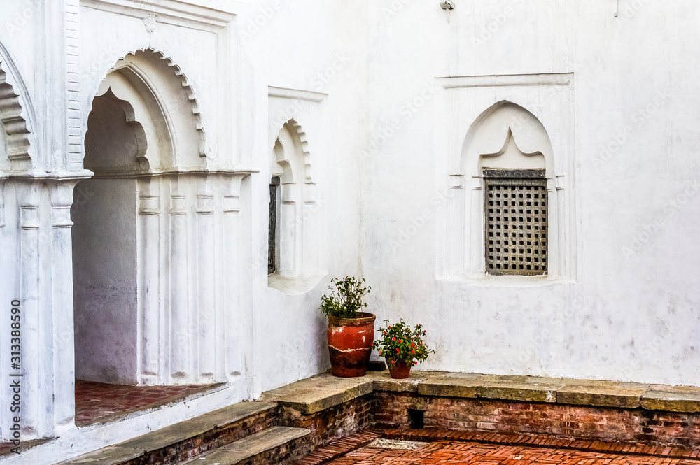 White interior courtyard wall with arched stone doorways and windowsin ...