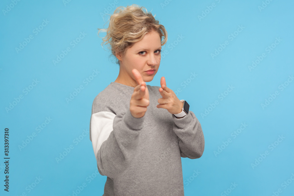 Dangerous woman with curly hair in sweatshirt pointing finger gun to ...