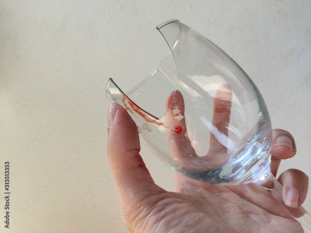 Close up view of broken glass in hand and blood on fingers sliced a ...