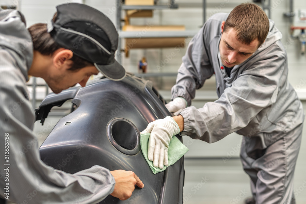 An employee of the paint shop of the automobile plant conducts training ...
