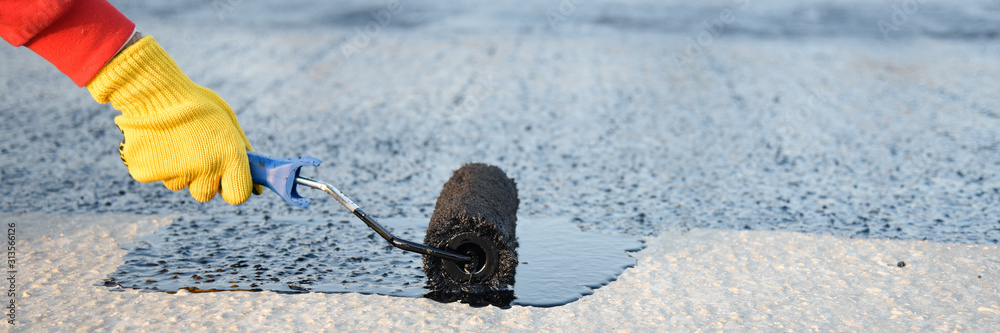 Worker applies bitumen mastic on the foundation Stock Photo | Adobe Stock