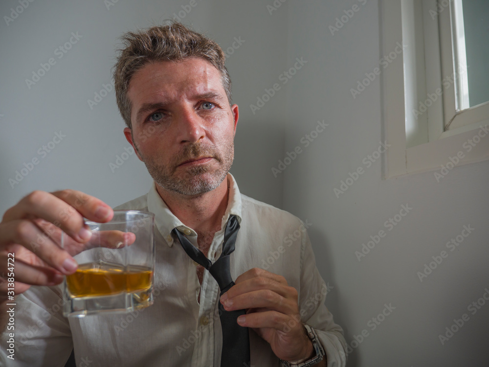 portrait of 30s to 40s alcoholic man in lose necktie drinking desperate ...