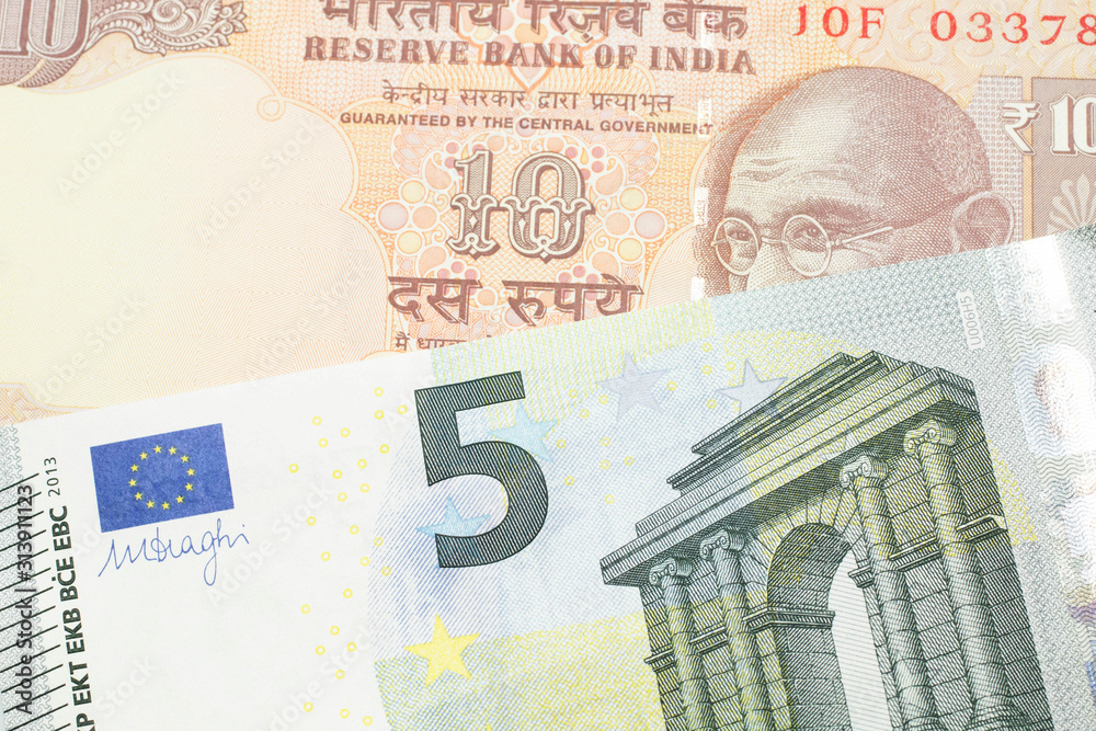 An orange, Indian ten rupee bill, close up with a blue and green five ...