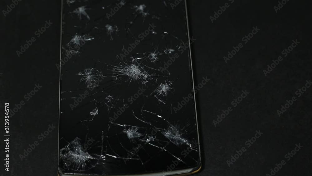 Vidéo Stock A broken phone on black background. Crushed device with ...