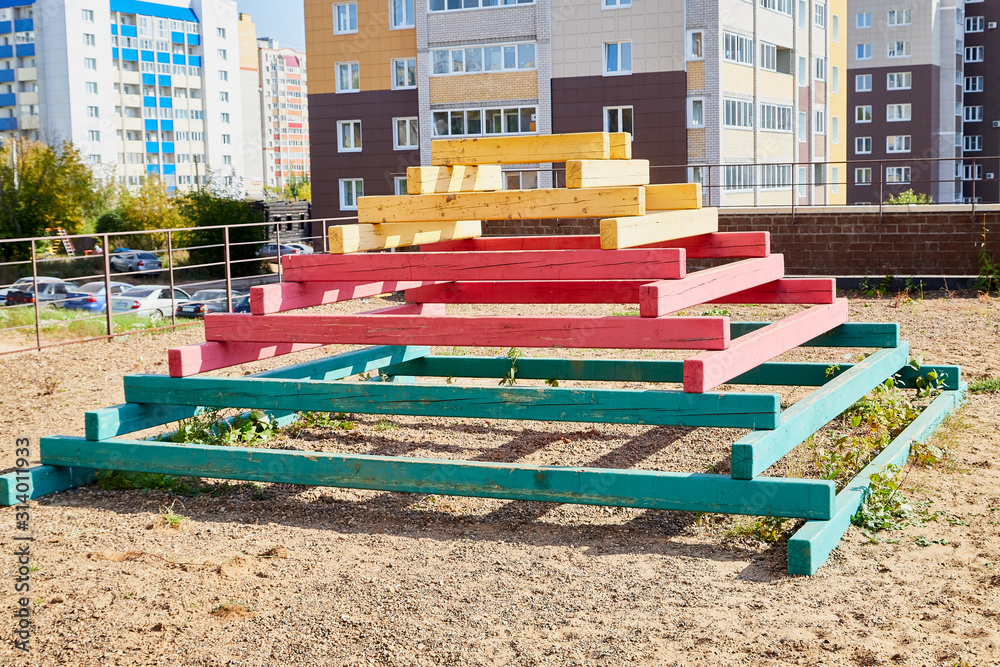 Sand with wooden pyramid with steps which is playground equipment on a ...