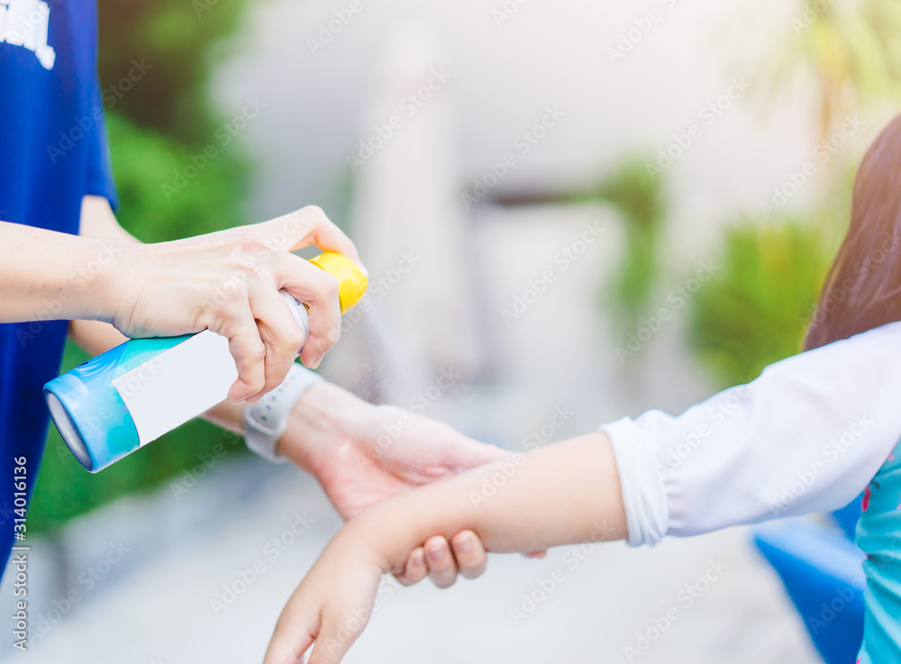 Mom and kid g use mosquito spray.Spraying insect repellent on skin ...