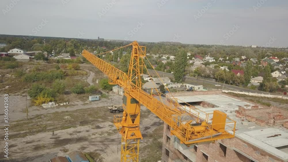 Two crane operators in overalls repair a high-rise tower crane working ...