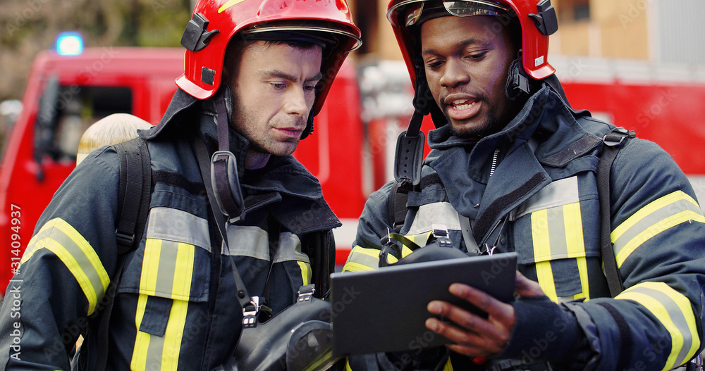 Portrait of two firefighters in fire fighting operation, fireman in ...