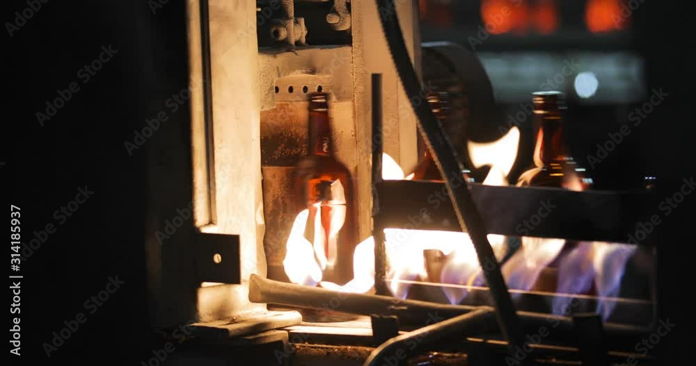 Video „Glass bottles moving along a conveyor line fall under an open ...