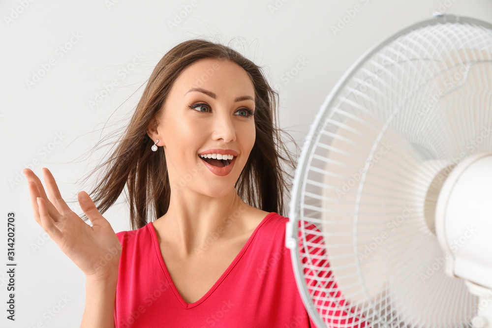 Happy woman with electric fan on white background Stock Photo | Adobe Stock