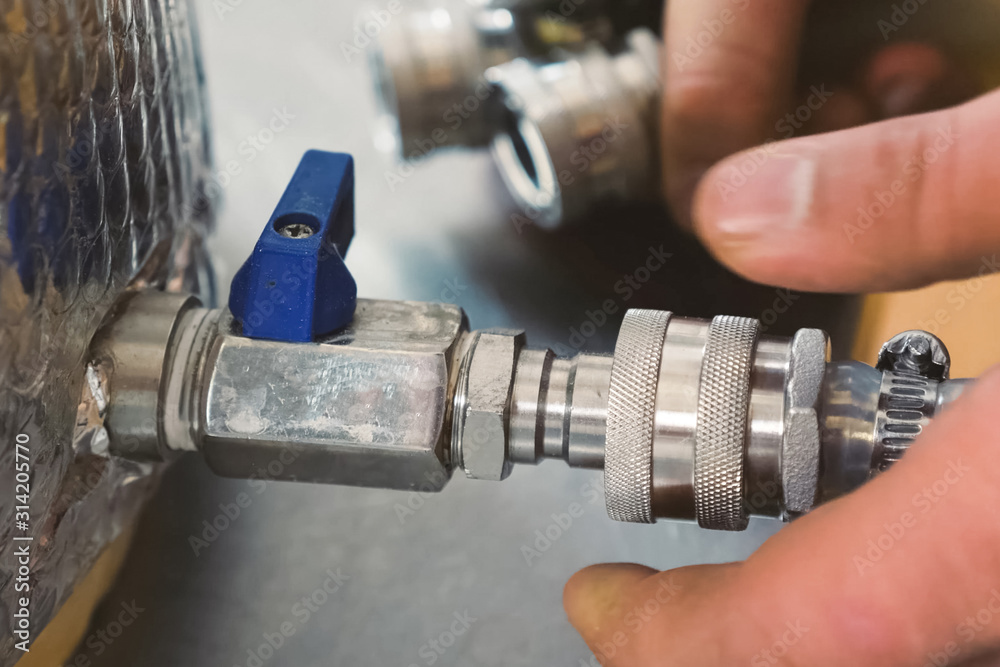 Installation of crane on a tank with liquid. Ball valve and pipe ...