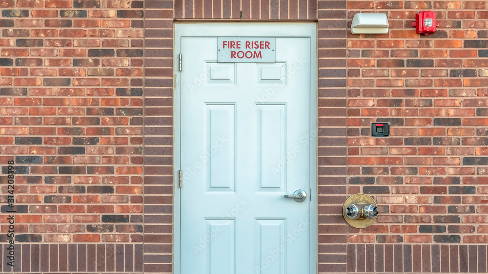 Panorama Fire Riser Room sign on the white wood door of a building with ...