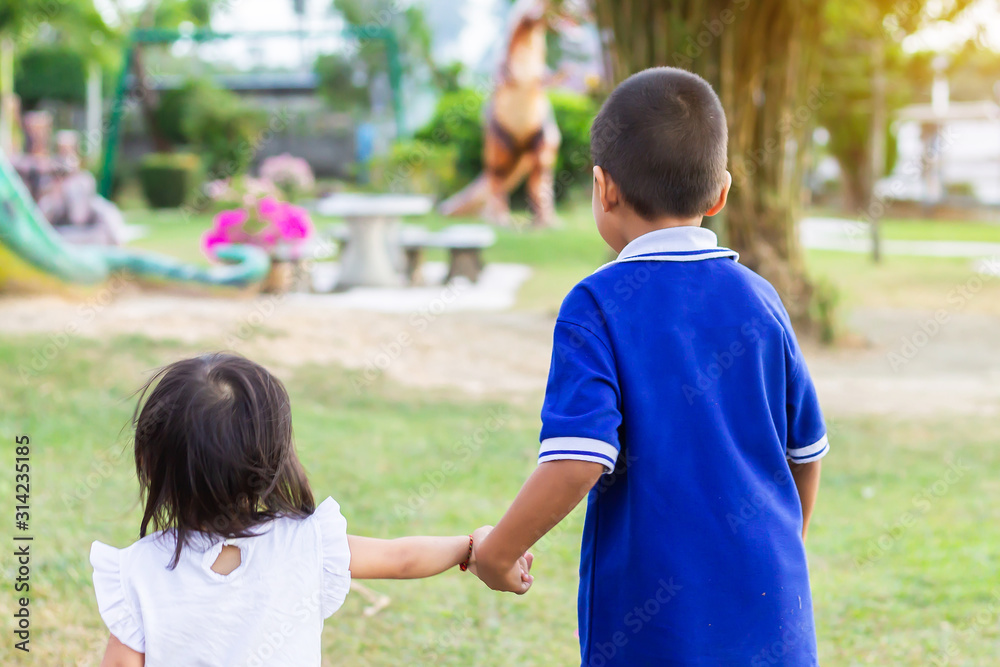 Happy Asian child brother hand in hand a little baby sister to walking ...