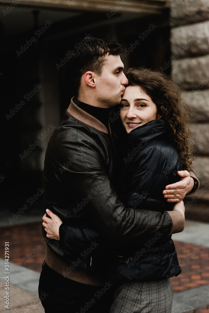 Attractive young couple walking near castle. Wife and husband kissing ...