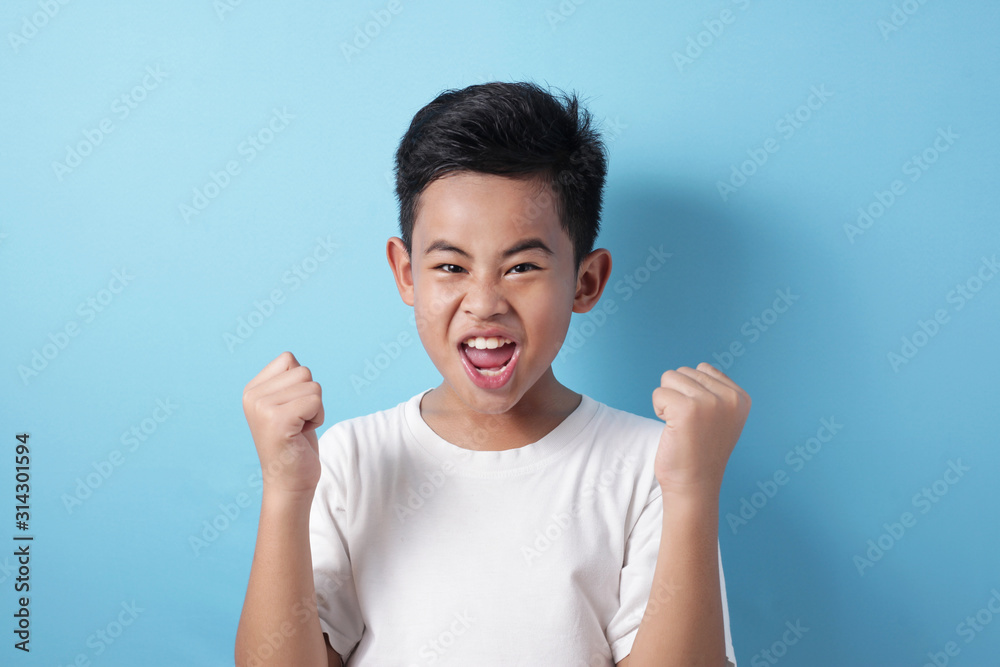 Happy success Asian boy shows winning gesture Stock Photo | Adobe Stock