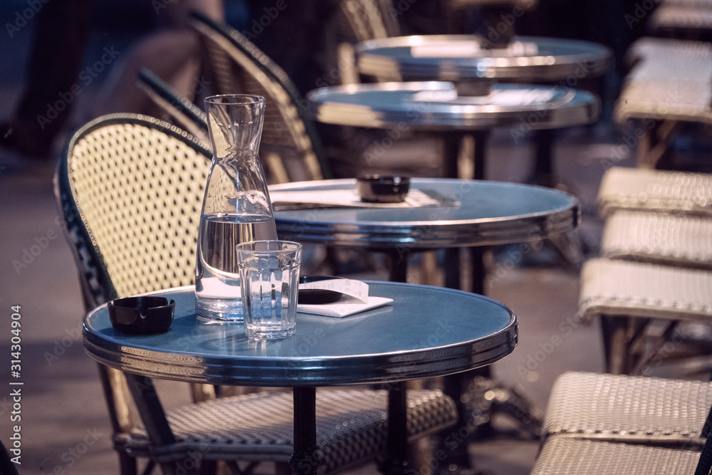 Paris cafe tables with wter carafe and glass and wicker chairs Stock ...