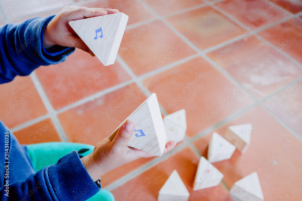 Child holding some wooden blocks with musical notes to learn music ...