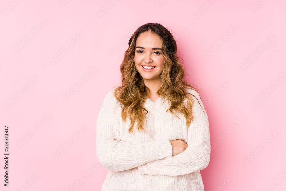 Young curvy woman posing in a pink background isolated who feels ...