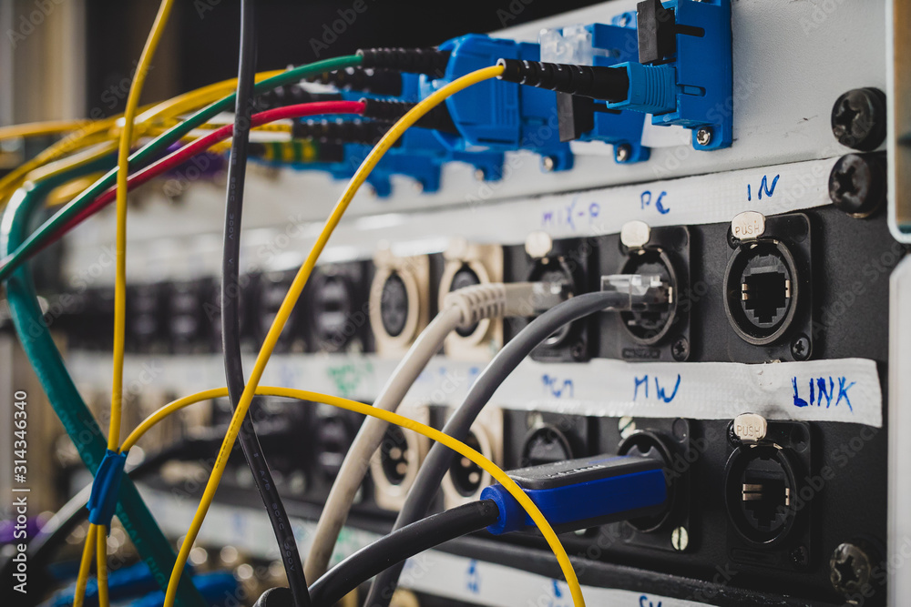 Different BNC SDI UTP and optical signal cables plugged in the back of ...