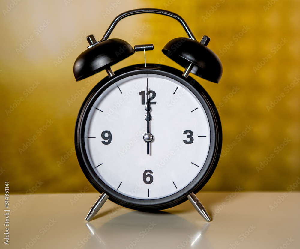 Alarm clock with simple and minimalist design. Arrows pointing at 12 o ...