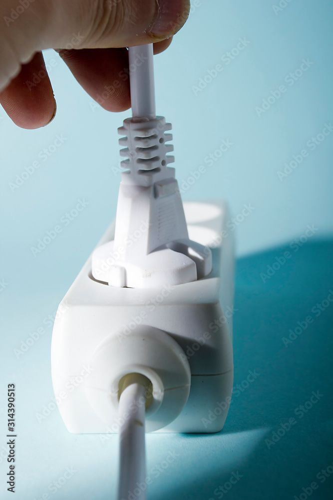 Connecting the plug to a power outlet Stock Photo | Adobe Stock