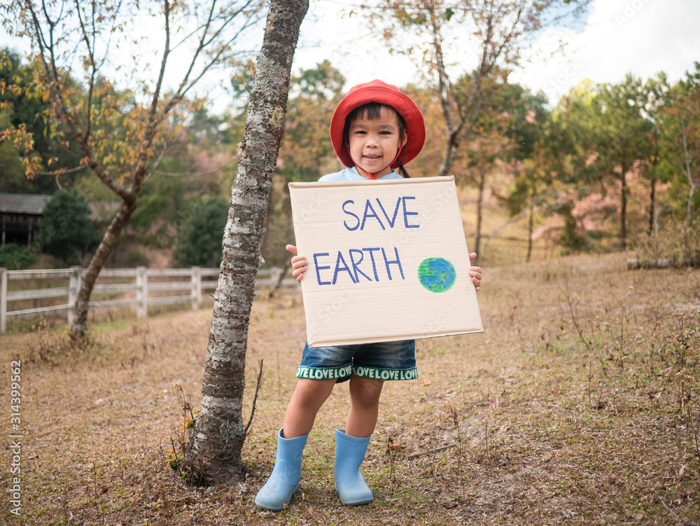 The little child girl holding "Save The Earth" Poster showing a sign ...