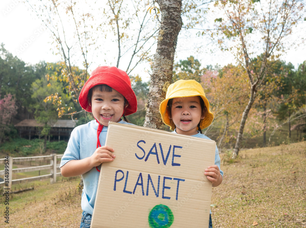 Two little child girl siblings holding "Save the planet" Poster showing ...