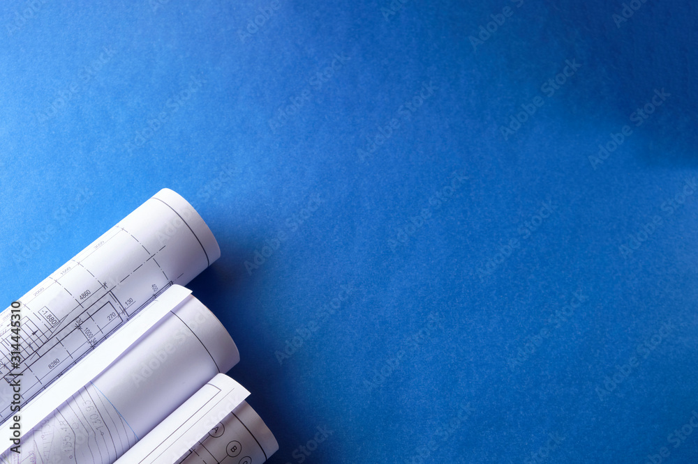 Rolled engineering drawings at blue background with copy space Stock ...