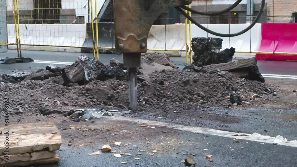 Jackhammer Crumbles Asphalt Pavement. Impact tip splits the thick ...