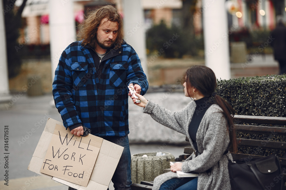 Homeless in a city. Man asking for food. Man with a tablet. Girl ...