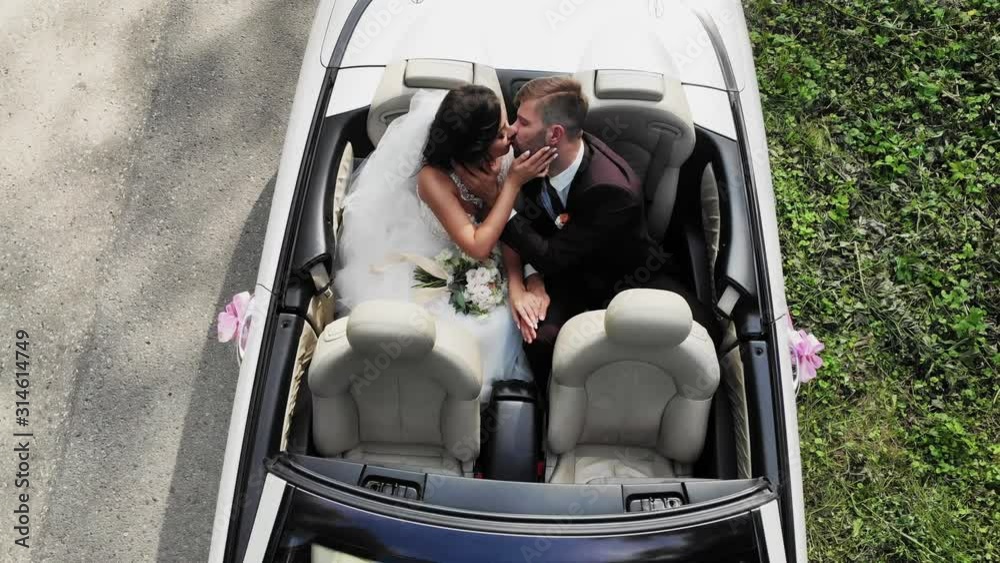 Happy bride kiss groom, newlywed wedding couple is driving a ...