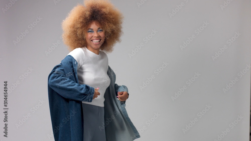 portrait in studio mixed race black woman in denim oversized shirt and ...