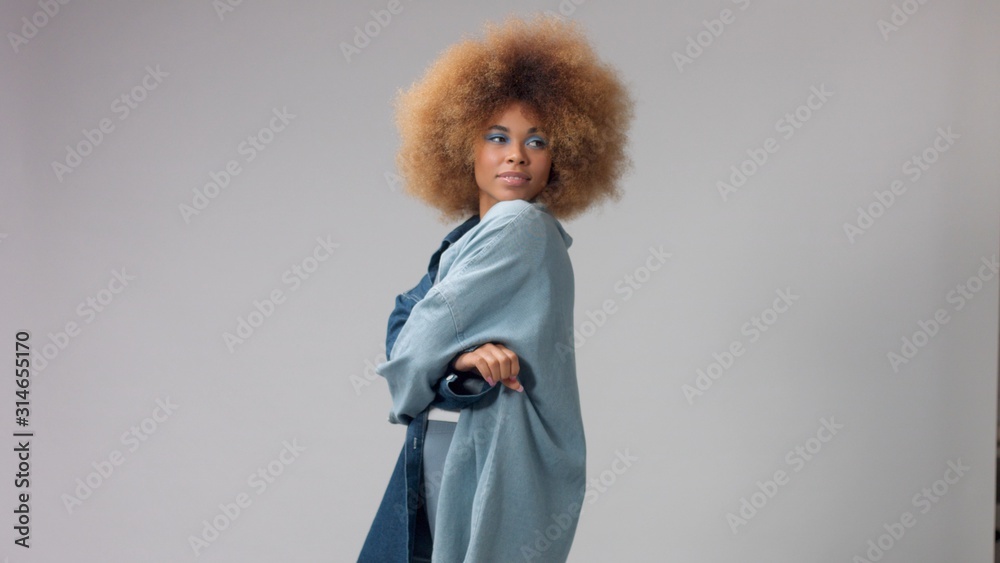 portrait in studio mixed race black woman in denim oversized shirt and ...