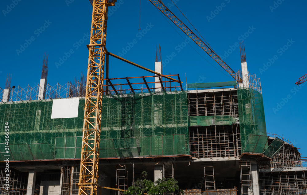 Crane and building construction site against blue sky. Metal ...