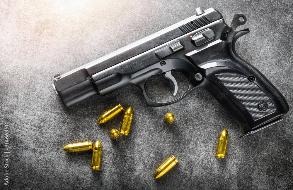 Detail of 9mm pistol, bullets and handcuffs. Gun with ammunition on ...