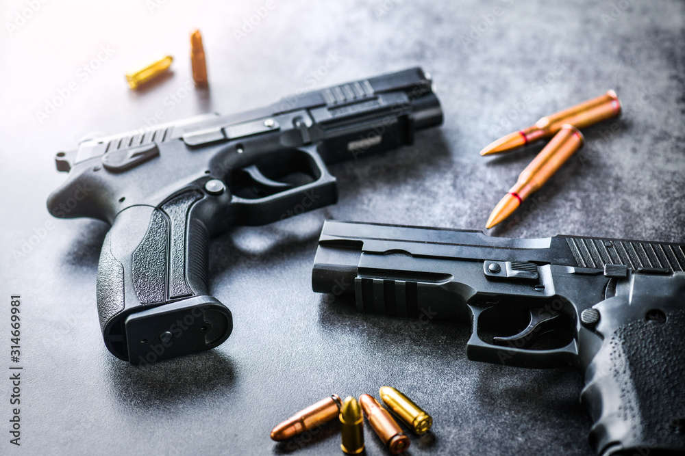 Hand guns on dark stone table top view. ammunition or bullets at black ...