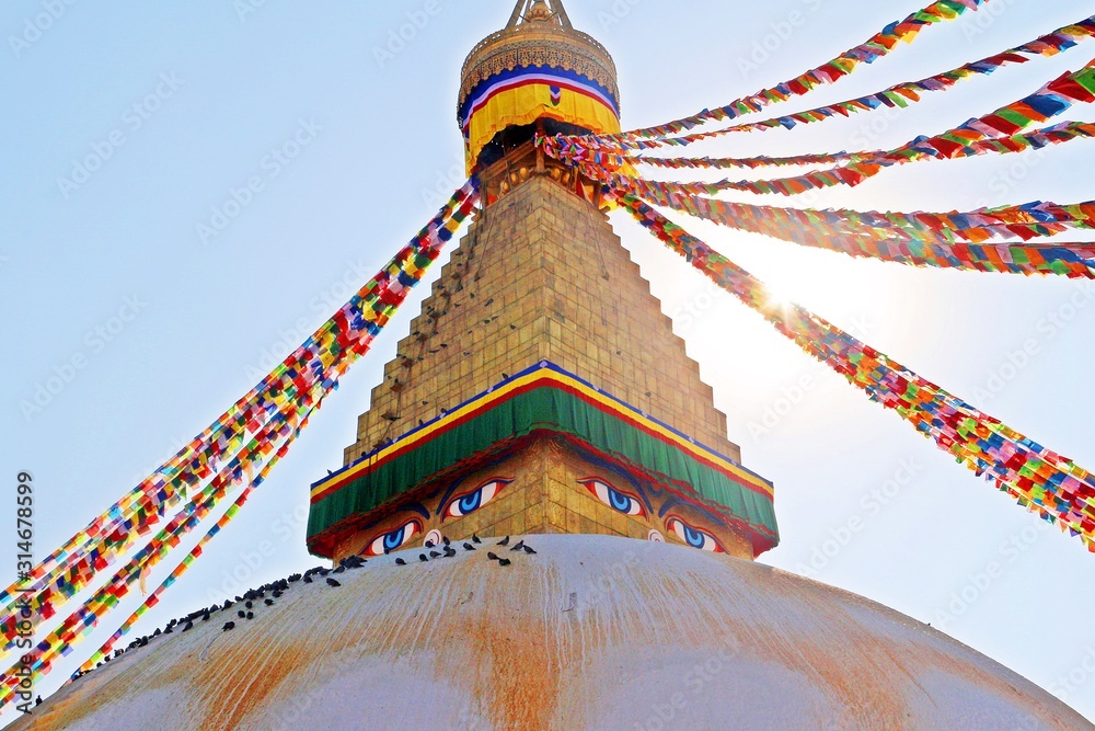 One side of Boudha Stupa / Sun bright through the flags at Boudhanath ...