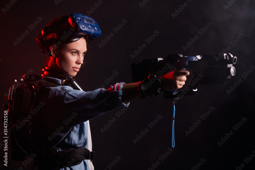Young caucasian woman with gun for virtual reality game aimed her ...