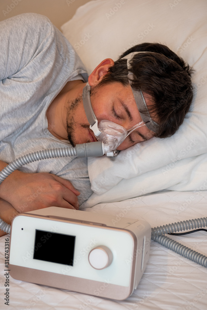 Healthy young man wearing ( CPAP Mask ) nasal mask and using CPAP ...