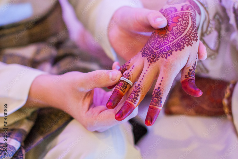 The groom is dressing the ring to the bride's hand during the Malay ...