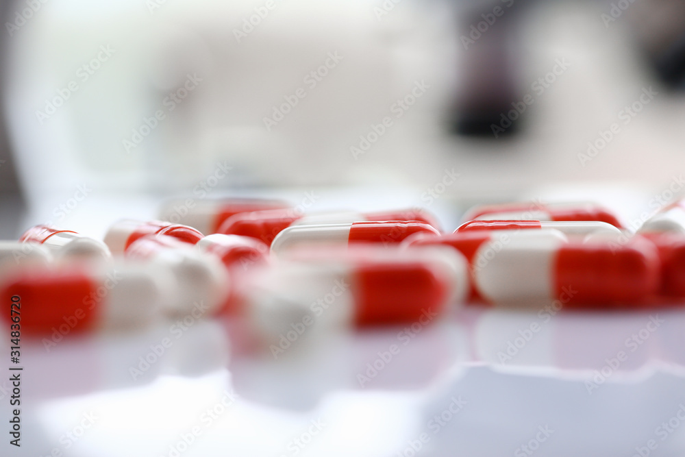 Red tablets scattered on the table of the pharmaceutical laboratory ...