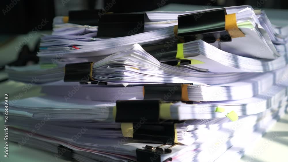 Piles unfinished documents reports files with sticky notes, overwork ...
