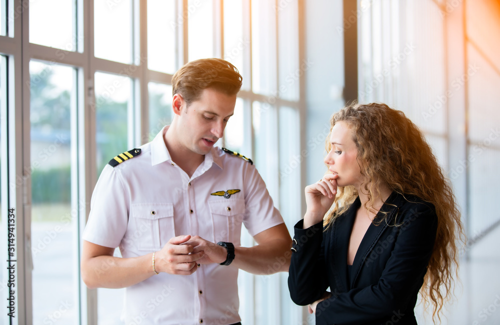Commercial pilot in uniform greeting clients near small private ...