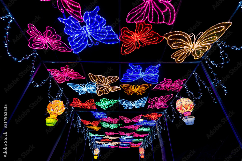 Up view of illuminated butterflies forming a illuminated corridor or ...