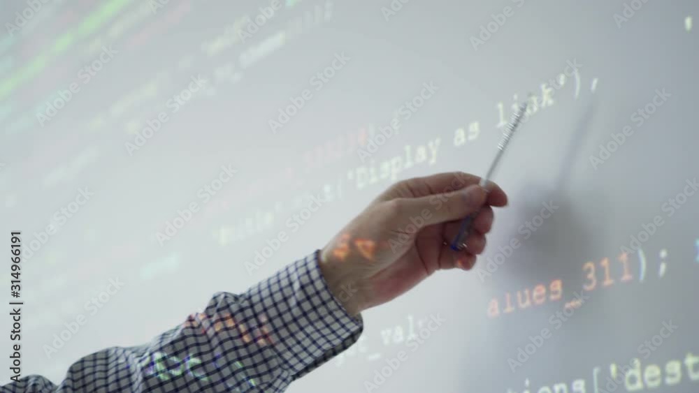 Pan left view of anonymous teacher pointing at whiteboard with code ...