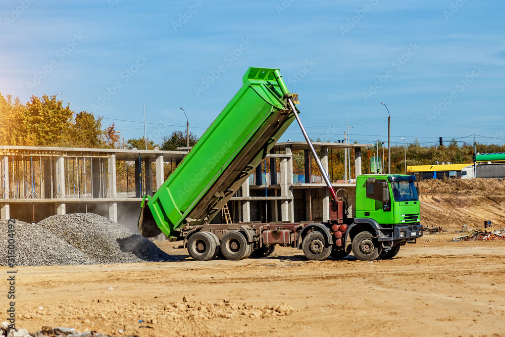 Foto de Construction truck tipping dumping gravel on road construction ...