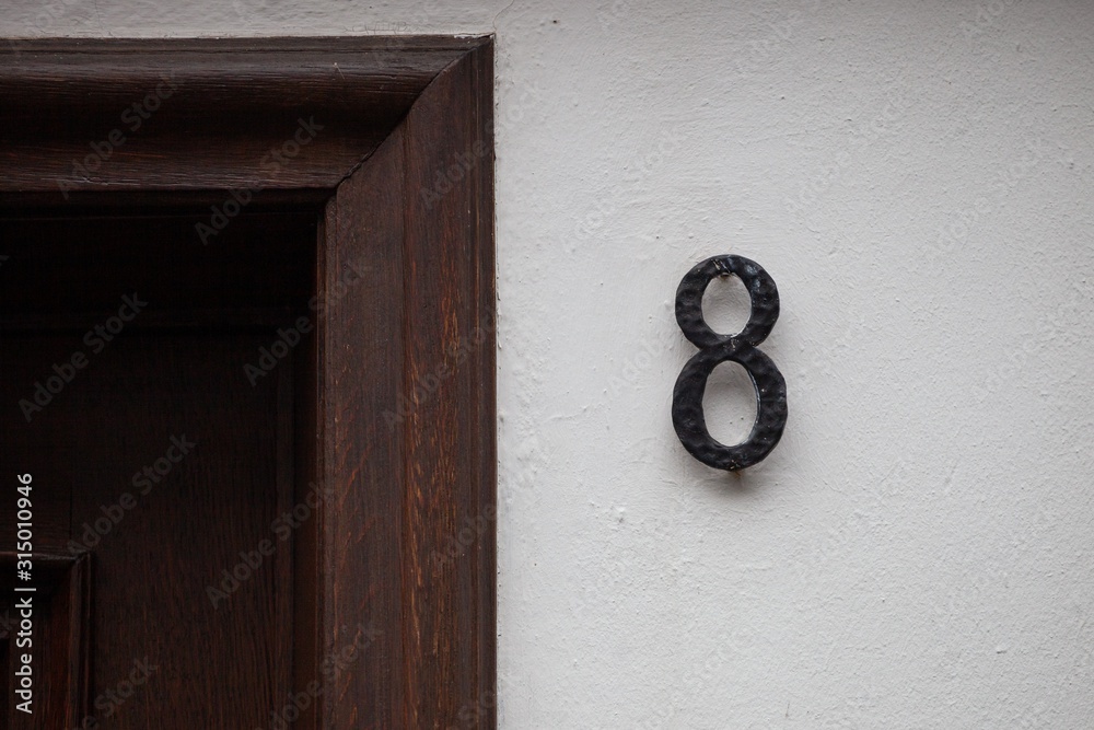 vintage number 8 on white wall with door frame Stock Photo | Adobe Stock