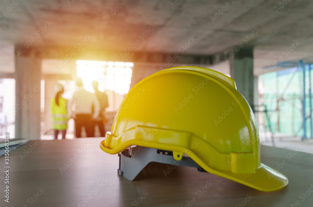 construction. yellow safety helmet on desk with team of engineer or ...