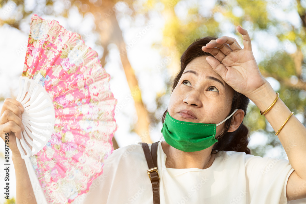 Asian senior woman fanning and sweat on face suffer from sunburn very ...