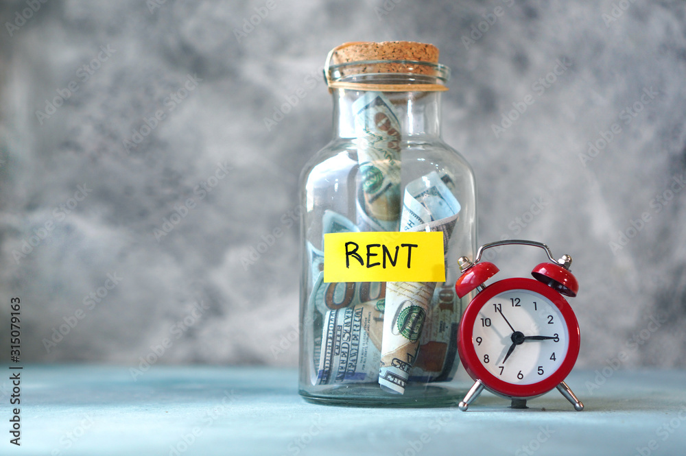 Rent. Money for rental concept with glass jar labeled rent filled with ...